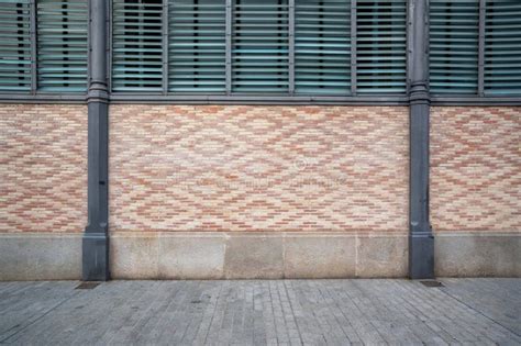 Brick Wall With Metal Columns And Window Shutters Forming A Geometric