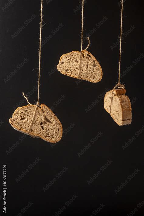 Slice Of Rustic Artisanal Bread Is Suspended Delicately By A Thin