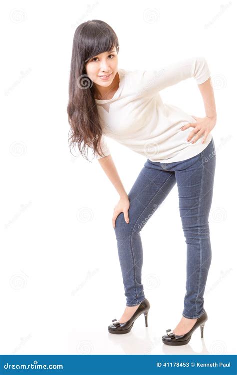 Asian Woman In White Jersey And Blue Jeans Leaning Over Stock Image