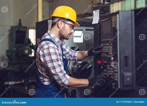 Industry Worker Entering Data In Cnc Machine At Factory Stock Image