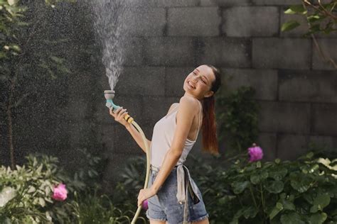 Premium Photo Girl Enjoying Water In The Heat Of Summer In The Garden