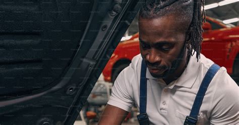 자동차 수리점에서 자동차 배터리 부하 테스터로 후드 아래에서 자동차 배터리를 테스트하는 다인종 수리공 사진 Unsplash의 자동차 이미지