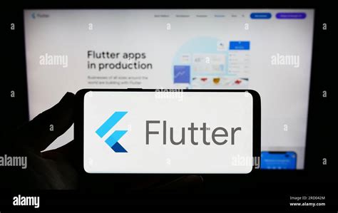 Person Holding Smartphone With Logo Of Ui Software Development Kit