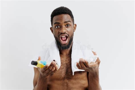 Confident Shirtless Man Showcasing Hygiene Products With A Toothbrush