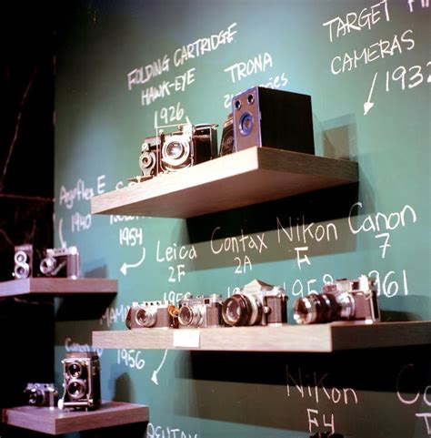 골동품 카메라 교육용 디스플레이 니콘 디스플레이 선반 라이카 레트로 카메라 매장 디스플레이 목조 선반 박물관 전시 벽에 있는 텍스트 빈티지 사진 빈티지