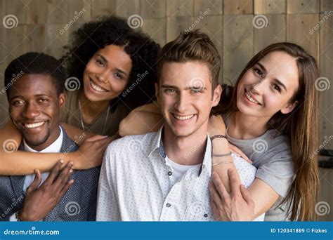 Multiracial Couples Hugging Smiling To Camera Posing For Pictur Stock