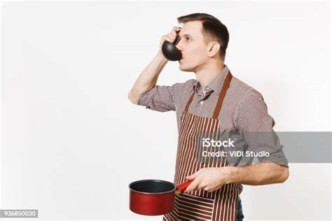 젊은 남자 요리사 또는 웨이터 스트라이프 브라운 앞치마에 셔츠 지주 고 레드 빈 Stewpan 검은 국자에 고립 된 흰색 배경 남자가 정부 또는 Houseworker입니다