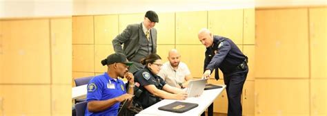 Chief Information Security Officer Looks At Laptop With Ucpd Team At Station Information