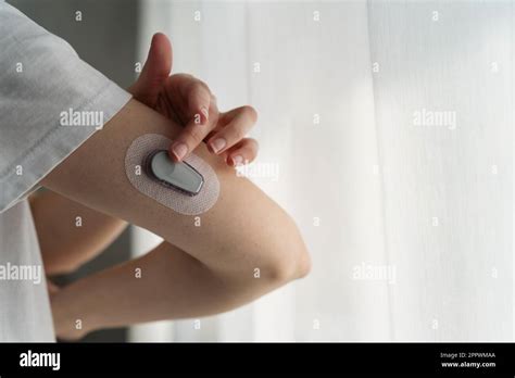 Close Up Of A Woman Attaching A Continuous Glucose Monitor To Her Arm Stock Photo Alamy