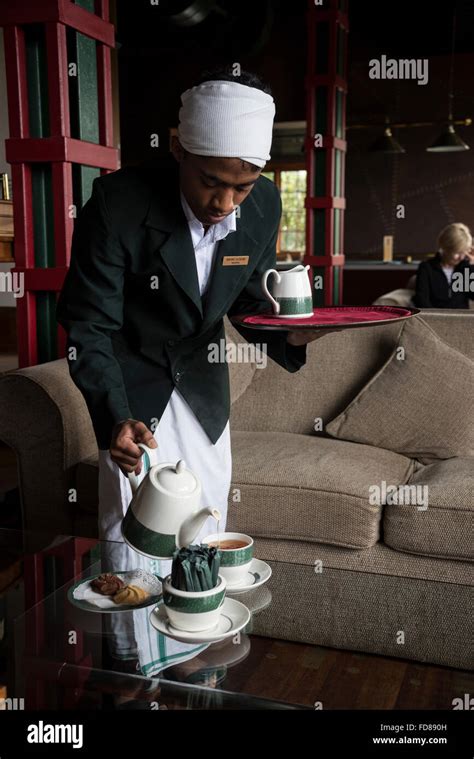 A Tea Boy A Member Of The Hotel Staff Serving Locally Grown Tea At The