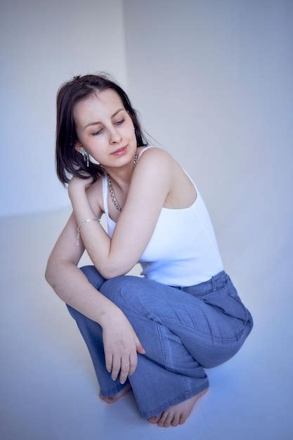 Premium Photo Young Teenage Girl Sits On A White Cyclorama In The Studio