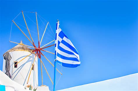 유명한 여행 장소 그리스 산토리니 섬의 오이아 빌리지에서 그리스 국기가 있는 전통 풍차의 그림 같은 전망 가로 이미지 컴포지션 0명에 대한 스톡 사진 및 기타 이미지