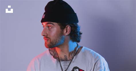 오른팔에 파란색과 검은색 문신이 있는 흰색 크루넥 티셔츠를 입은 남자 사진 Unsplash의 무료 서드 베리 이미지