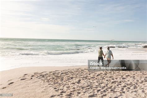 햇볕이 잘 드는 해변에서 손을 잡고 걷는 선임 다인종 커플의 전체 길이 남아프리카공화국에 대한 스톡 사진 및 기타 이미지 남아프리카공화국 명랑한 사람들 Istock