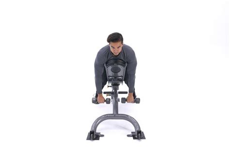 Подъем гантелей перед собой лежа на наклонной скамье лицом вниз Musclefit