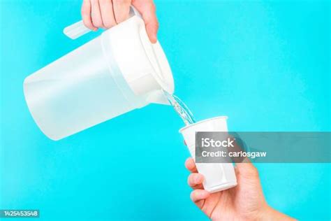 플라스틱 주전자에서 푸른 배경에 일회용 컵에 물을 붓는 것 물에 대한 스톡 사진 및 기타 이미지 물 따르기 일회용 컵 Istock