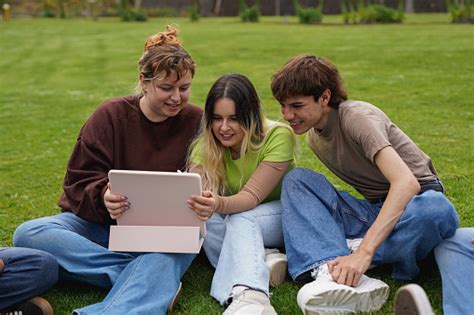 학교 건물 밖 잔디밭에 앉아 태블릿으로 함께 배우는 어린 학생들 대학 교육 및 청소년 개념 건물 외관에 대한 스톡 사진 및 기타 이미지 Istock