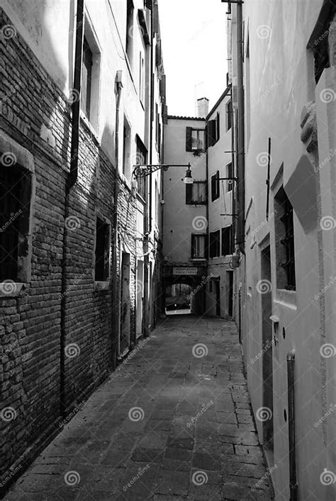 Black And White Shot Of A Narrow Pavement Passage Between Monotonous
