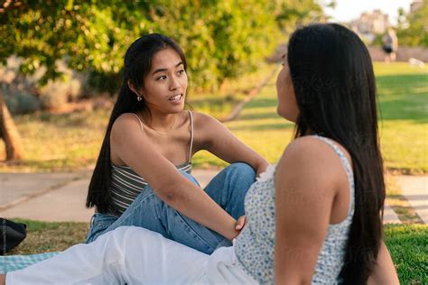 Best Friends Talking In The Park By Stocksy Contributor Lucas Ottone