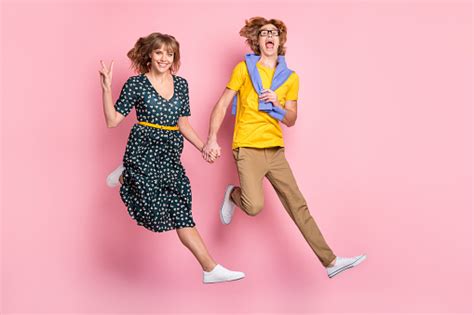 핑크 파스텔 컬러 배경에 고립 된 V 기호를 보여주는 아름다운 트렌디 한 쾌활한 커플 점프의 전체 길이 바디 사이즈 보기 커플에 대한 스톡 사진 및 기타 이미지 Istock