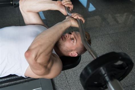 Premium Photo Bodybuilder Exercising Triceps With Barbell In Gym