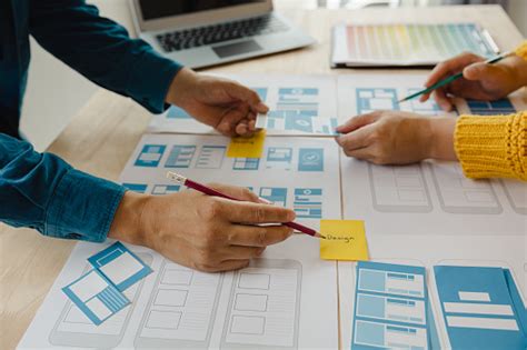 Ux 개발자와 Ui 디자이너가 현대 사무실에서 고객 요약 및 색상 코드와 함께 테이블에 모바일 앱 인터페이스 와이어프레임