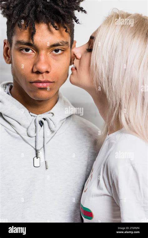 Blonde Young Woman Kissing Her Serious African Boyfriend His Cheek