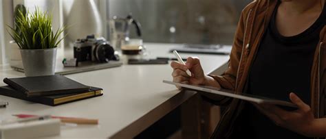 스튜디오에서 공급 카메라 및 장식과 함께 작업대에 앉아있는 동안 디지털 태블릿을 사용하는 여성 사진 작가 디자인에 대한 스톡 사진 및 기타 이미지 Istock