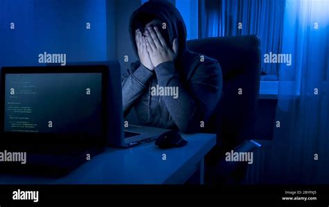stressed male programmer holding hands on his face while working on