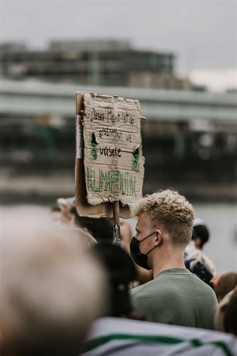 글씨가 적힌 팻말을 들고 있는 남자 사진 Unsplash의 무료 쾰른 이미지