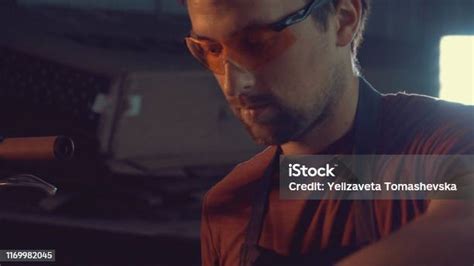 테마 중소 기업 자전거 수리 안전 고글 장갑과 앞치마를 착용 젊은 백인 갈색 머리 남자는 수리및 작업장 차고에서 자전거를 조정하기 위해 손 도구를 사용 강철에 대한 스톡