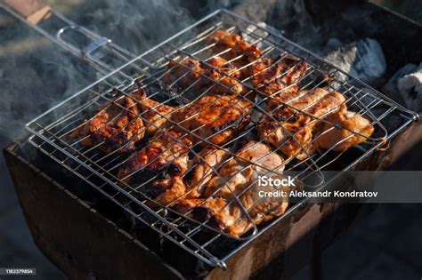 돼지 고기 또는 쇠고기 고기의 Shashlik 요리 과정에 클로즈업 연기가 올라가는 오픈 화재에 회색 탄 석탄 위에 바삭한 탄 껍질과 그릴에 고정 건강한 식생활에 대한 스톡