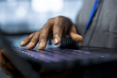 Close Up Of Engineer In Server Room Typing On Laptop Keyboard Stock