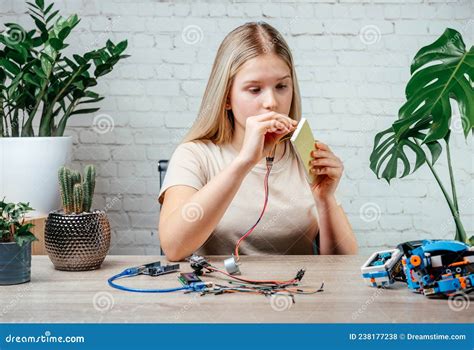 a blonde teen girl plugging cables to sensor chips while learning