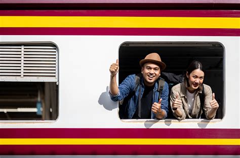 신혼 여행에 가방을 가진 커플 아시아 여행자 기차로 여행 창문 밖으로 머리를 찌르십시오 플랫폼 기차역 근처의 행복한 남자와 여자