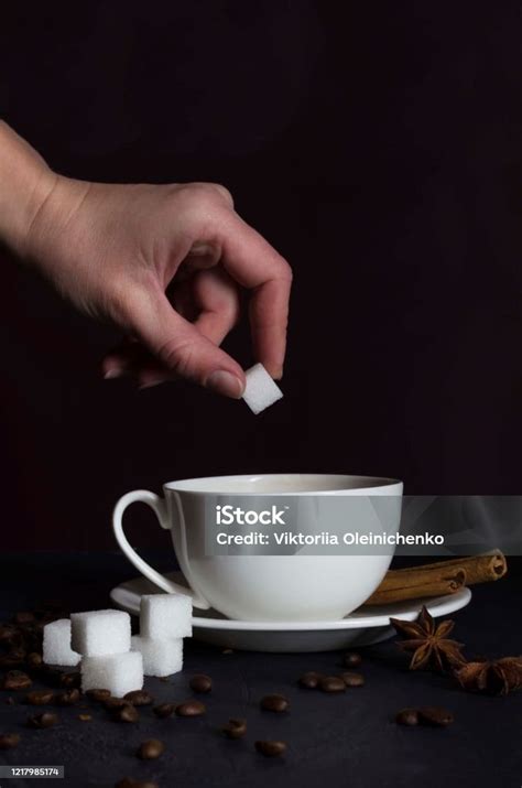 수직 샷 설탕 큐브 계피 스틱 검은 테이블에 커피 콩과 흰색 컵에 설탕 큐브를 넣어 여자 맛있는 토트 커피를 준비하는 과정 검은색에 대한 스톡 사진 및 기타 이미지 Istock