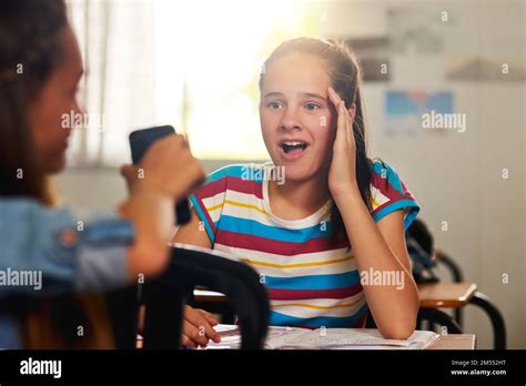 No Way A Young Schoolgirl Looking At Her Classmates Smartphone In Awe