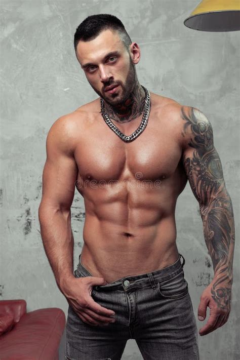 Fashion Portrait Of Naked Male Model With Tattoo And A Black Beard