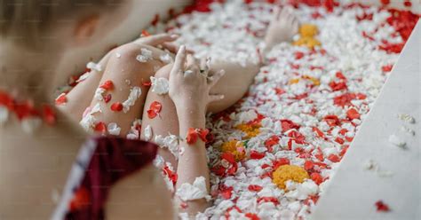 자연 피부 관리 개념입니다 열대 꽃이 있는 욕조에서 여성 다리에 선택적으로 초점을 맞춥니다 목욕에 누워 스파 절차를 즐기는 젊은 성인 소녀 사진 Unsplash의