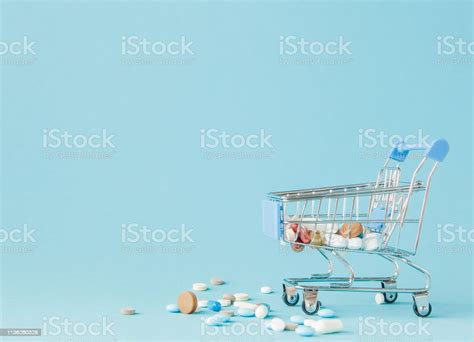 알 약 및 파란색 배경에 쇼핑 트롤리 의료 비용 약국 건강 보험 및 제약 회사 비즈니스 개념에 대 한 창의적인 아이디어 복사 공간 0명에 대한 스톡 사진 및 기타 이미지