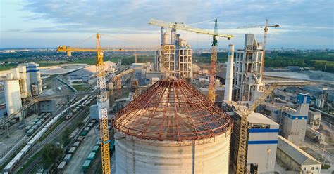 산업 생산 지역에서 높은 콘크리트 공장 구조와 타워 크레인으로 건설 중인 시멘트 공장의 조감도 제조 및 글로벌 산업 개념 사진 Unsplash의 사업 이미지