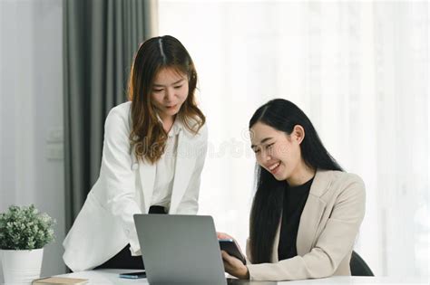 Two Professional Millennial Asian Startup Businesspeople Are Discussing Evaluation Data In A
