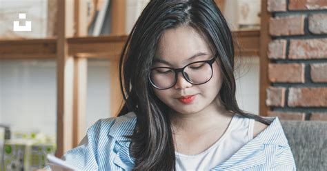 방 안의 탁자 옆에 앉아서 책을 읽고 있는 여자 사진 Unsplash의 무료 프놈펜 이미지