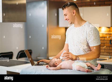 Dad Trying To Work While Standing With His Newborn Babe In Home Office Interior Stock Photo Alamy