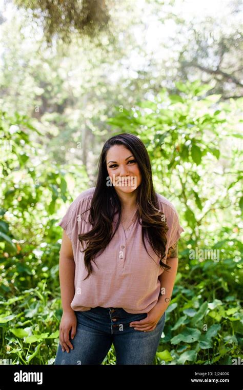 Mid 30s Mexican Woman Posing Surrounded By Foliage In San Diego Stock
