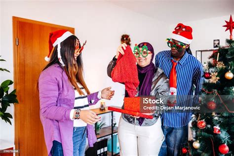 사무실에서 함께 새해를 축하하는 동료들 크리스마스 트리 앞에 서서 선물을 나누는 모습 12월 31일에 대한 스톡 사진 및 기타 이미지 12월 31일 20 24세 3