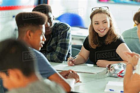 Smiling High School Girl Student Talking With Classmates In Classroom