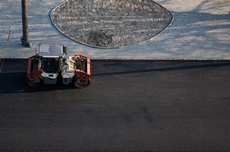 무거운 진동 롤러 압축기아스팔트 도로 롤러는 도로 건설 현장의 도로에 새로운 뜨거운 아스팔트를 누릅니다 아스팔트 포장 작업에서 무거운 진동 롤러 복구 0명에 대한 스톡 사진