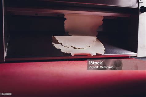 요리사 만들기 반죽 과자 시커 베이커 리 포밍 형성 반죽 압연 패스트리 금속 작업 테이블 닫는 손 프로세스 빵 Khinkali 반죽 롤러 기계 얇은 파스타 시트 상단 보기