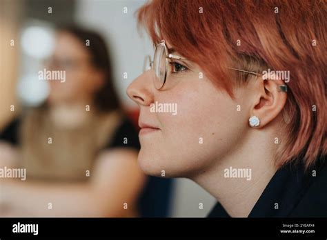 Side View Of Non Binary Person With Brown Hair Wearing Eyeglasses Stock